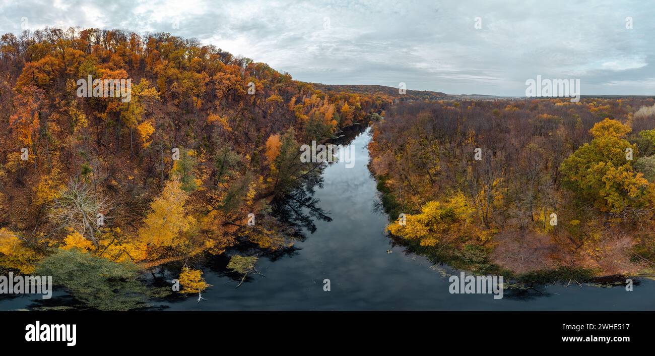 Aerial wide panorama of autumn river with forest and cloudy sky. Flying ...