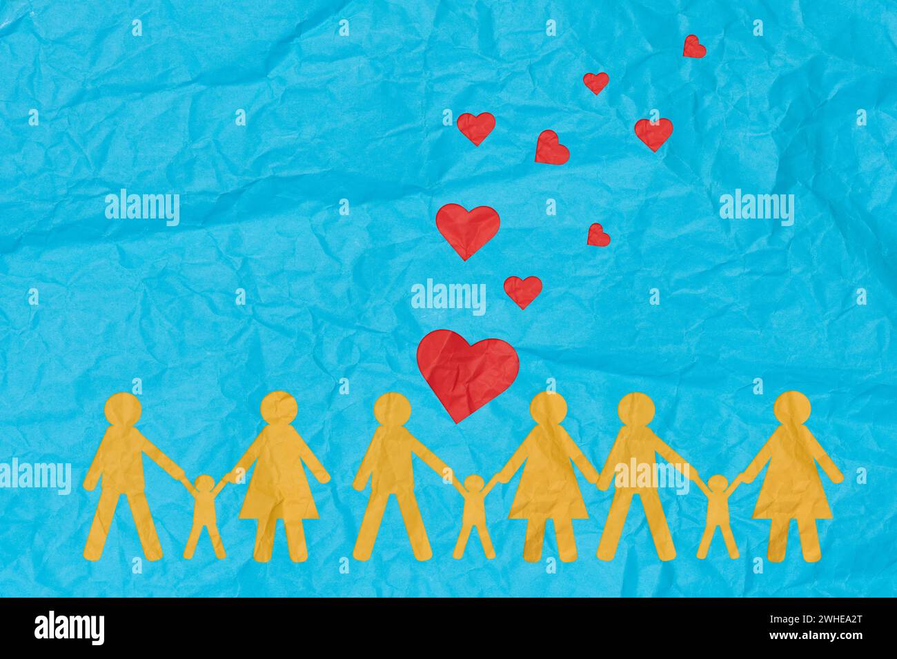 Cut out figures of a family dad, mom, and child holding hands on a blue ...