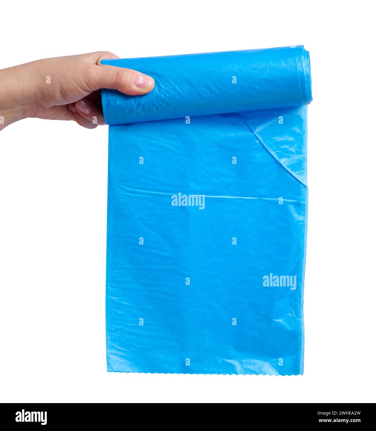 A woman's hand holds a roll of plastic bags for the trash can on a ...