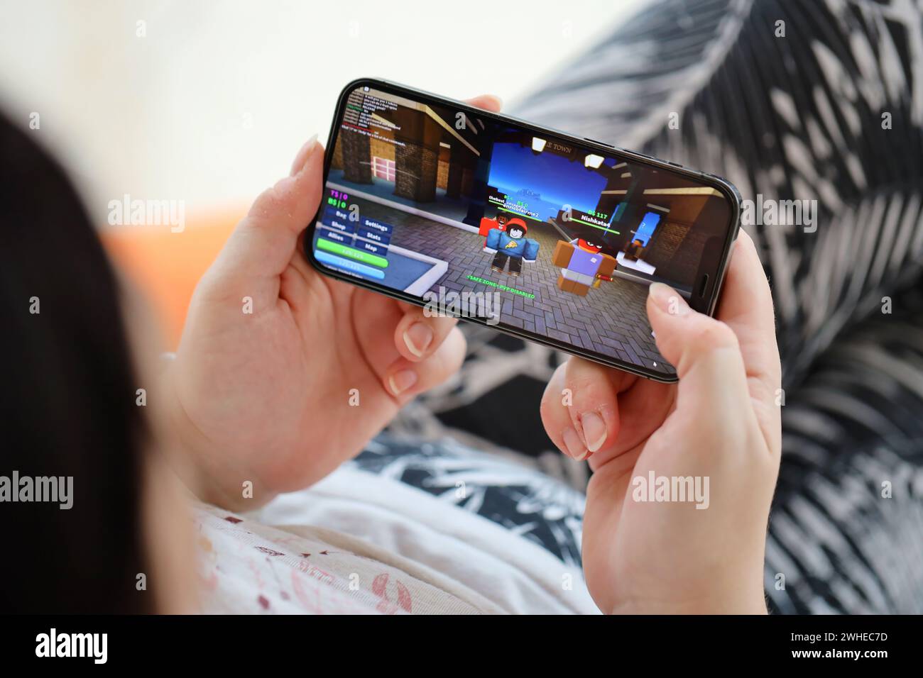 Roblox mobile iOS game on iPhone 15 smartphone screen in female hands ...