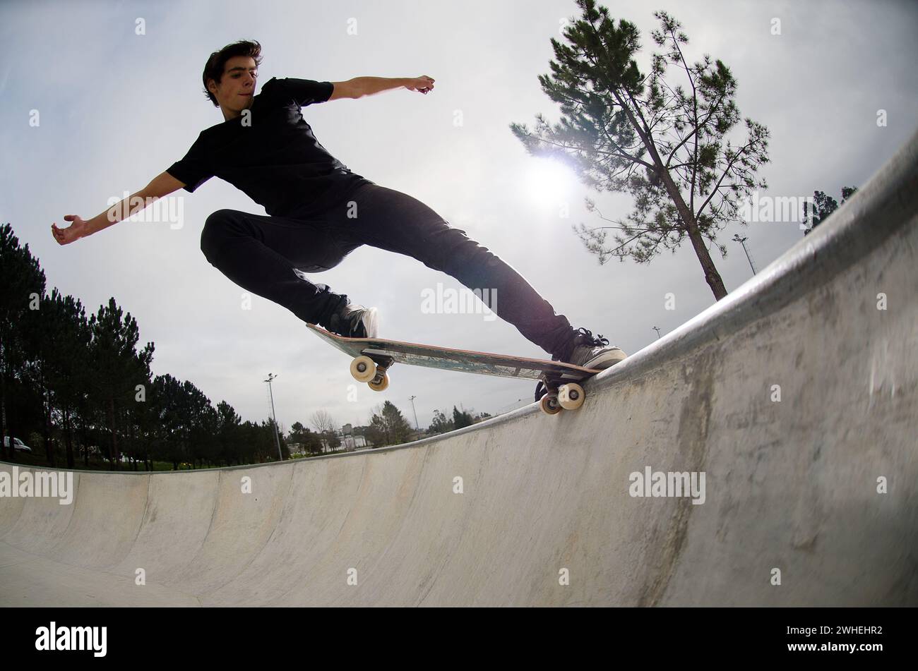 Skateboarder doing a tail slide Stock Photo - Alamy