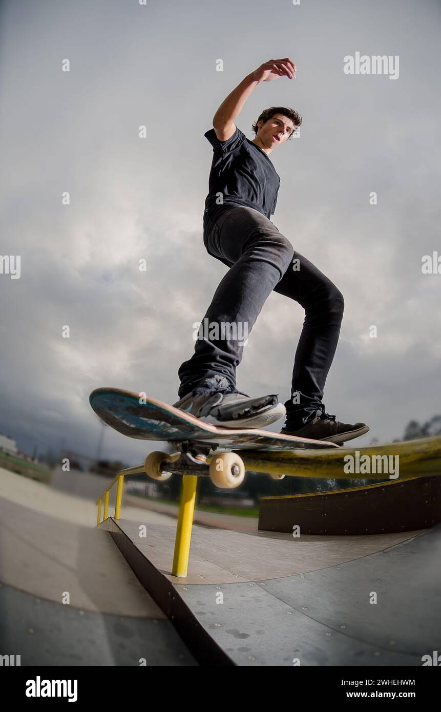 Skateboarder doing a board slide Stock Photo - Alamy