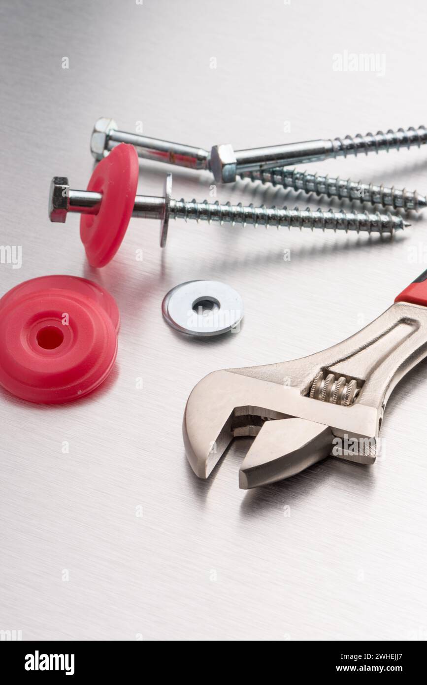 Spanner tool and screws on metal finish background Stock Photo - Alamy