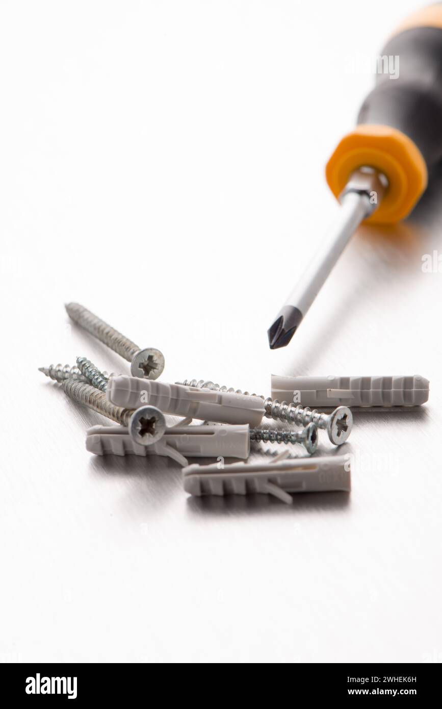 Screwdriver, screws and plastic dowels Stock Photo - Alamy