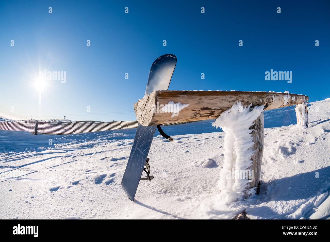Snowboard leaning on a wood rail Stock Photo - Alamy