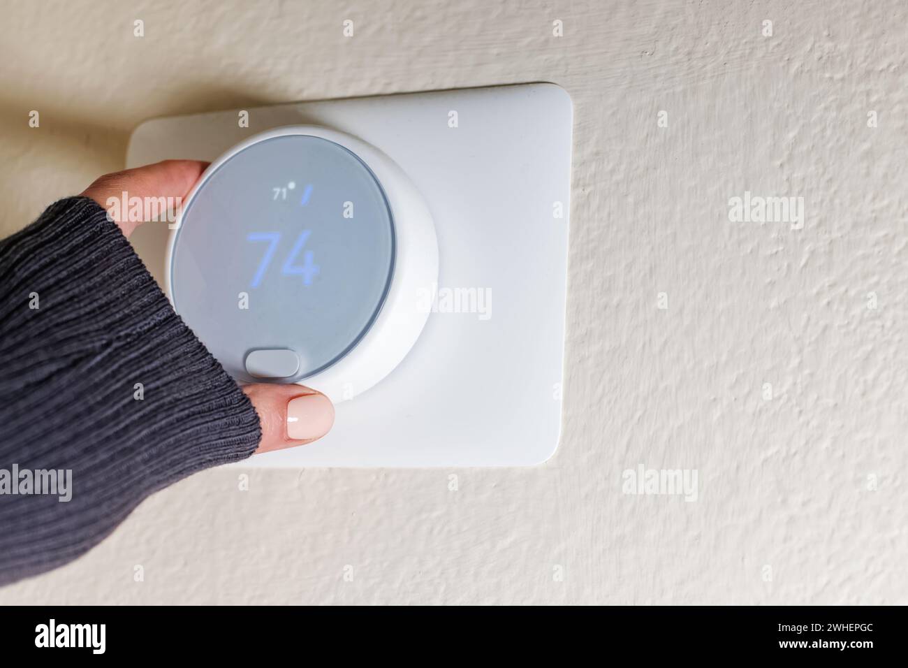 Female hand selecting temperature on modern thermostat, close-up Stock ...