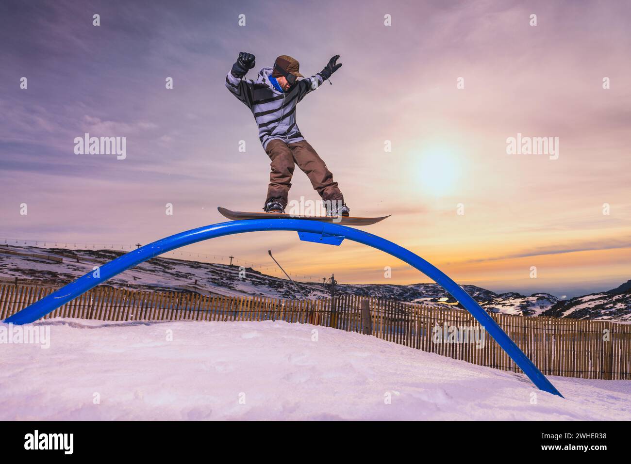 Snowboarder sliding on a rail Stock Photo - Alamy