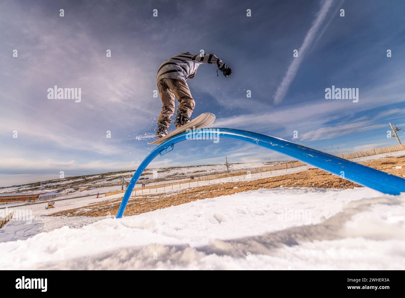 Snowboarder sliding on a rail Stock Photo - Alamy