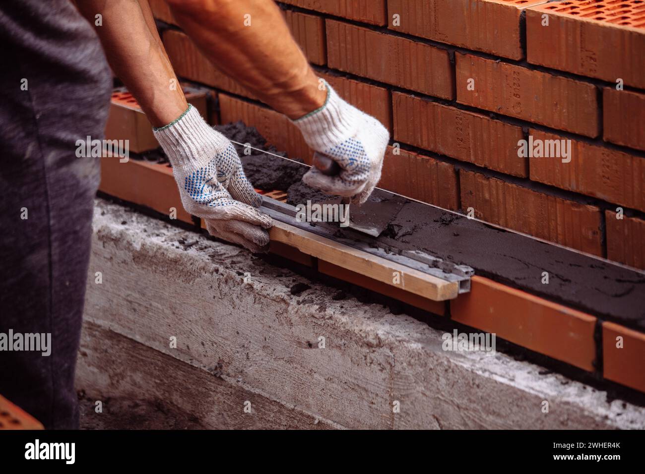 Builder trowels smears cement mortar on brick during bricklaying Stock ...