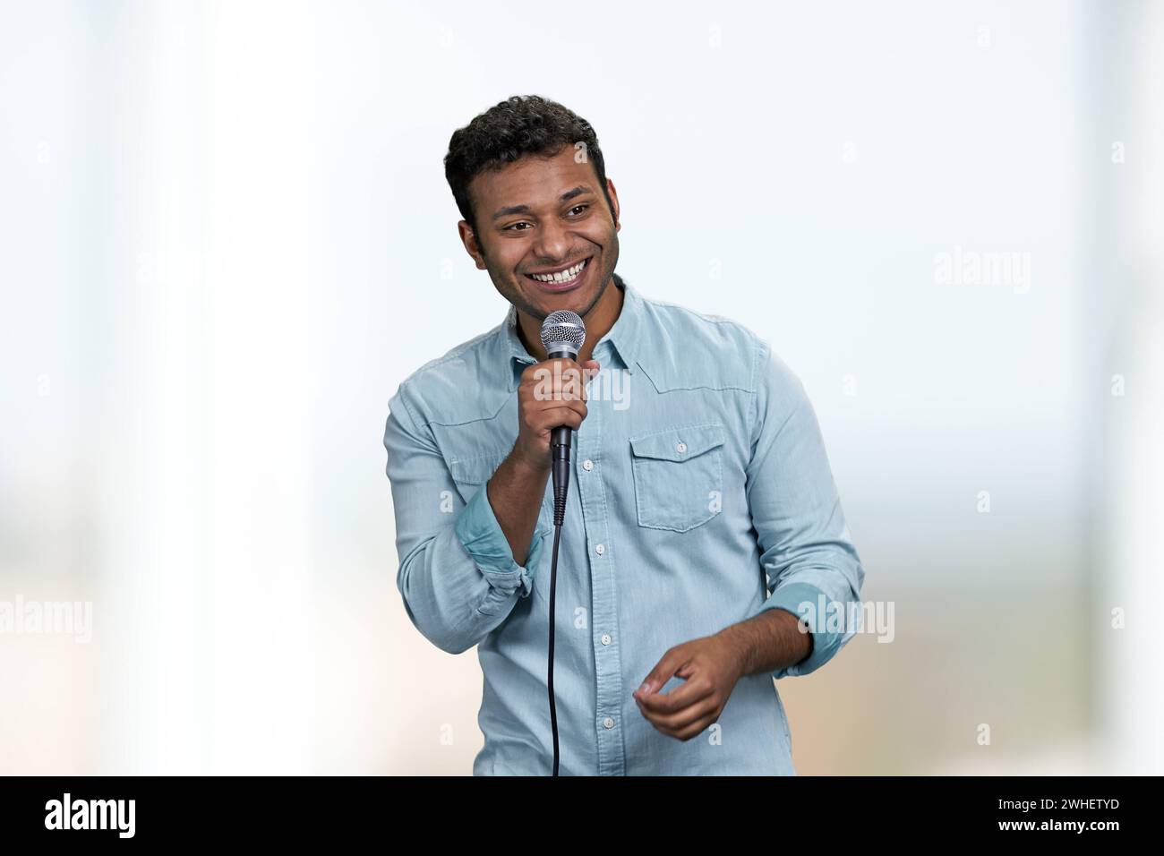 Happy cheerful man entertainer talking into microphone making speech or ...