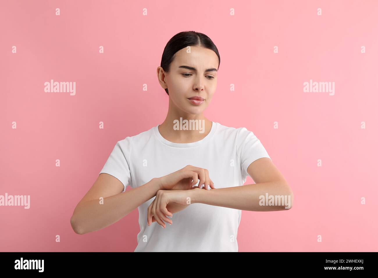 Woman with dry skin checking her arm on pink background Stock Photo - Alamy