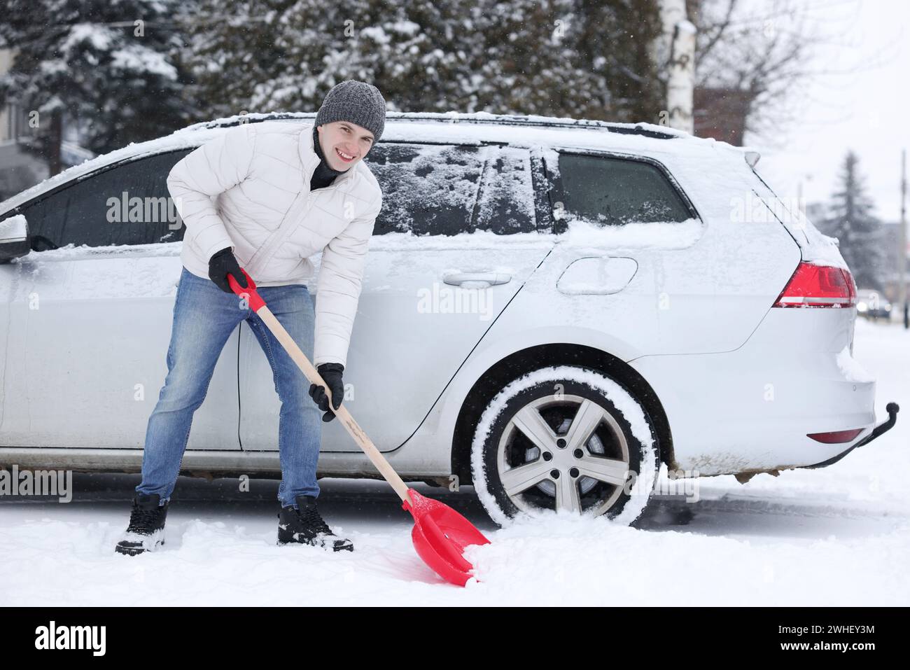 Man removing snow with shovel near car outdoors Stock Photo - Alamy