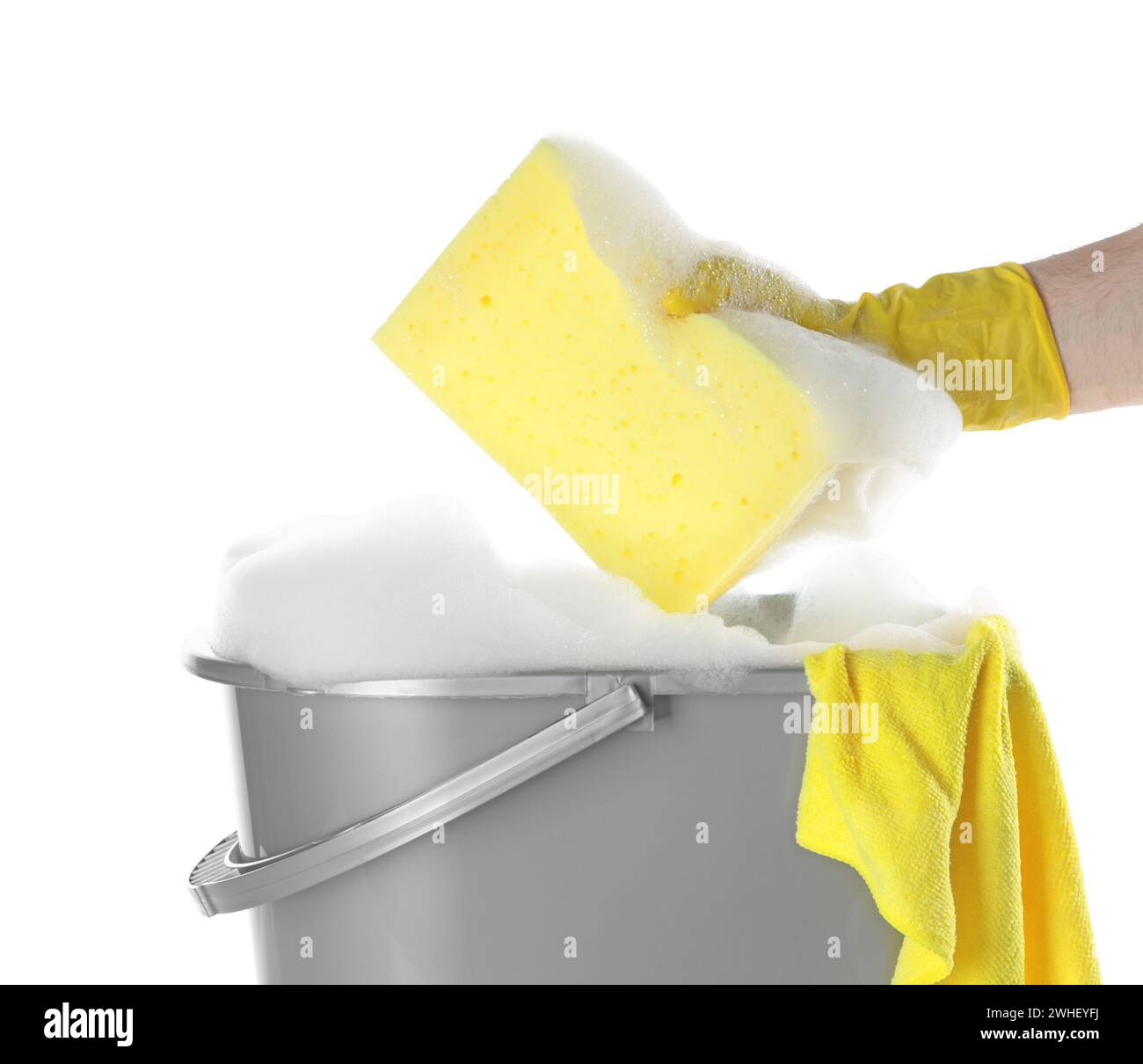 Man holding sponge over bucket with foam on white background, closeup ...