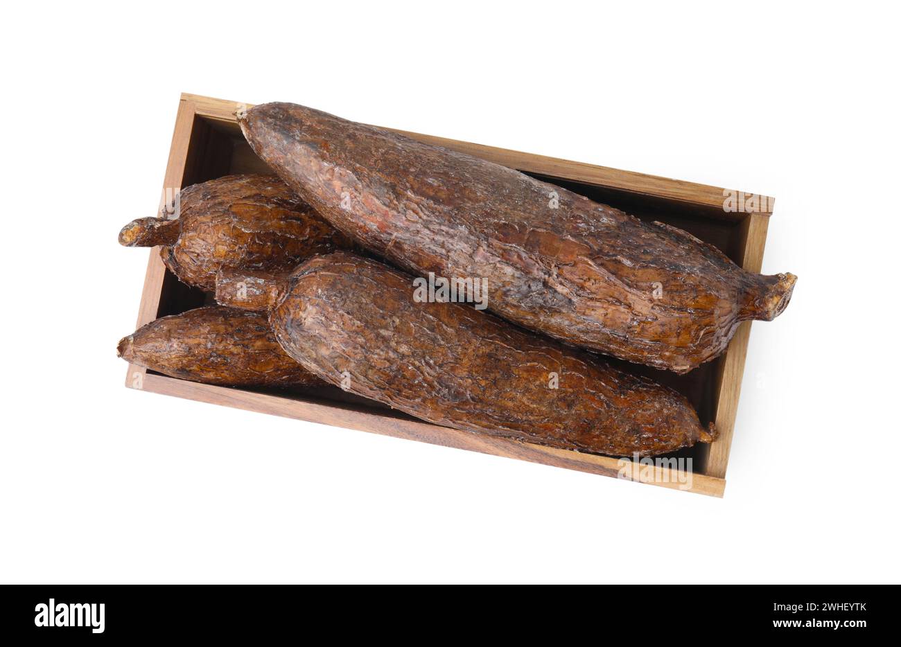 Whole cassava roots in wooden crate isolated on white, top view Stock ...