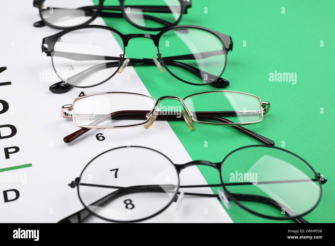 Vision test chart and glasses on green background, closeup Stock Photo ...