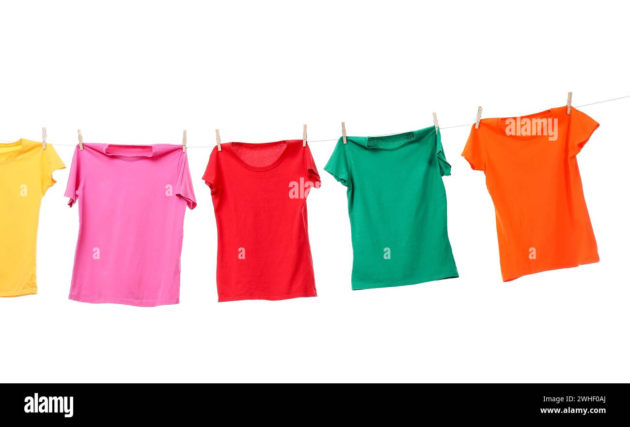 Different bright t-shirts drying on washing line against white ...