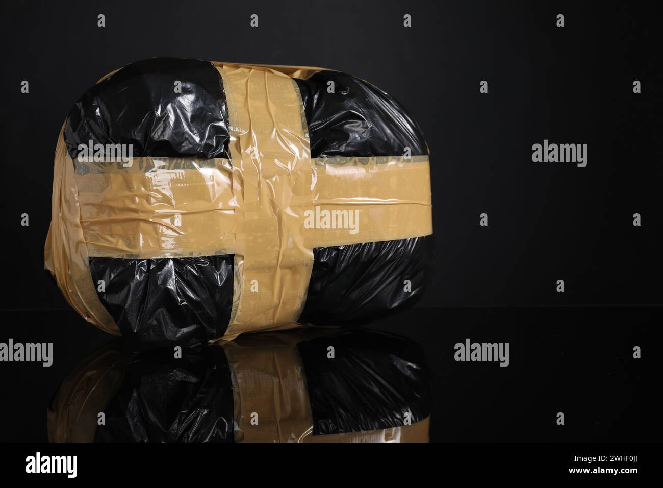 Smuggling and drug trafficking. Package with narcotics on black mirror ...