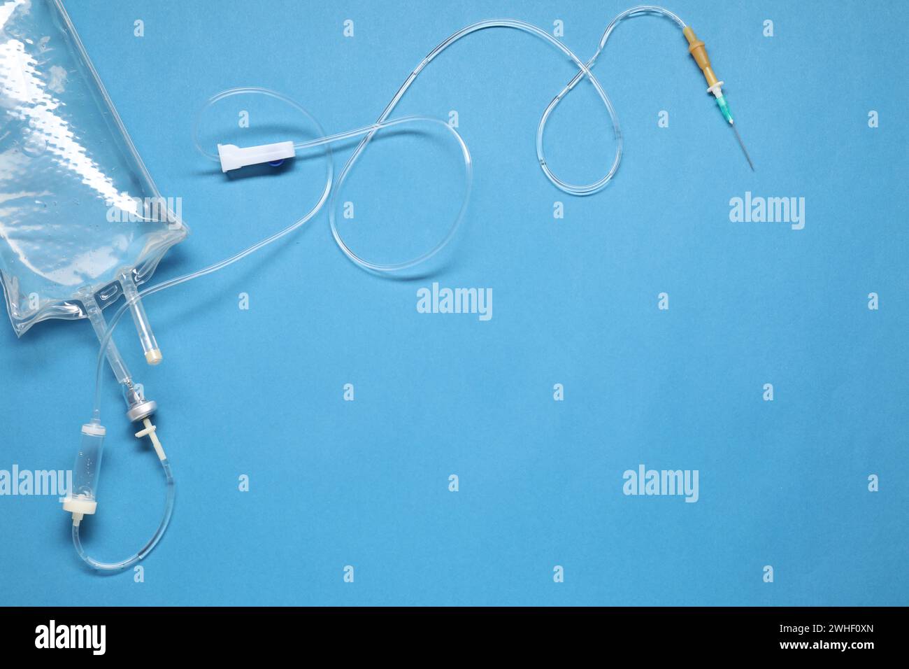 IV infusion set on light blue background, top view. Space for text ...