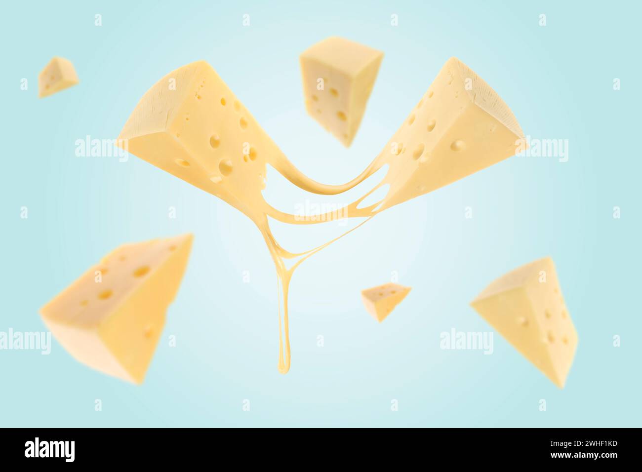 Pieces of cheese falling on light blue background Stock Photo - Alamy