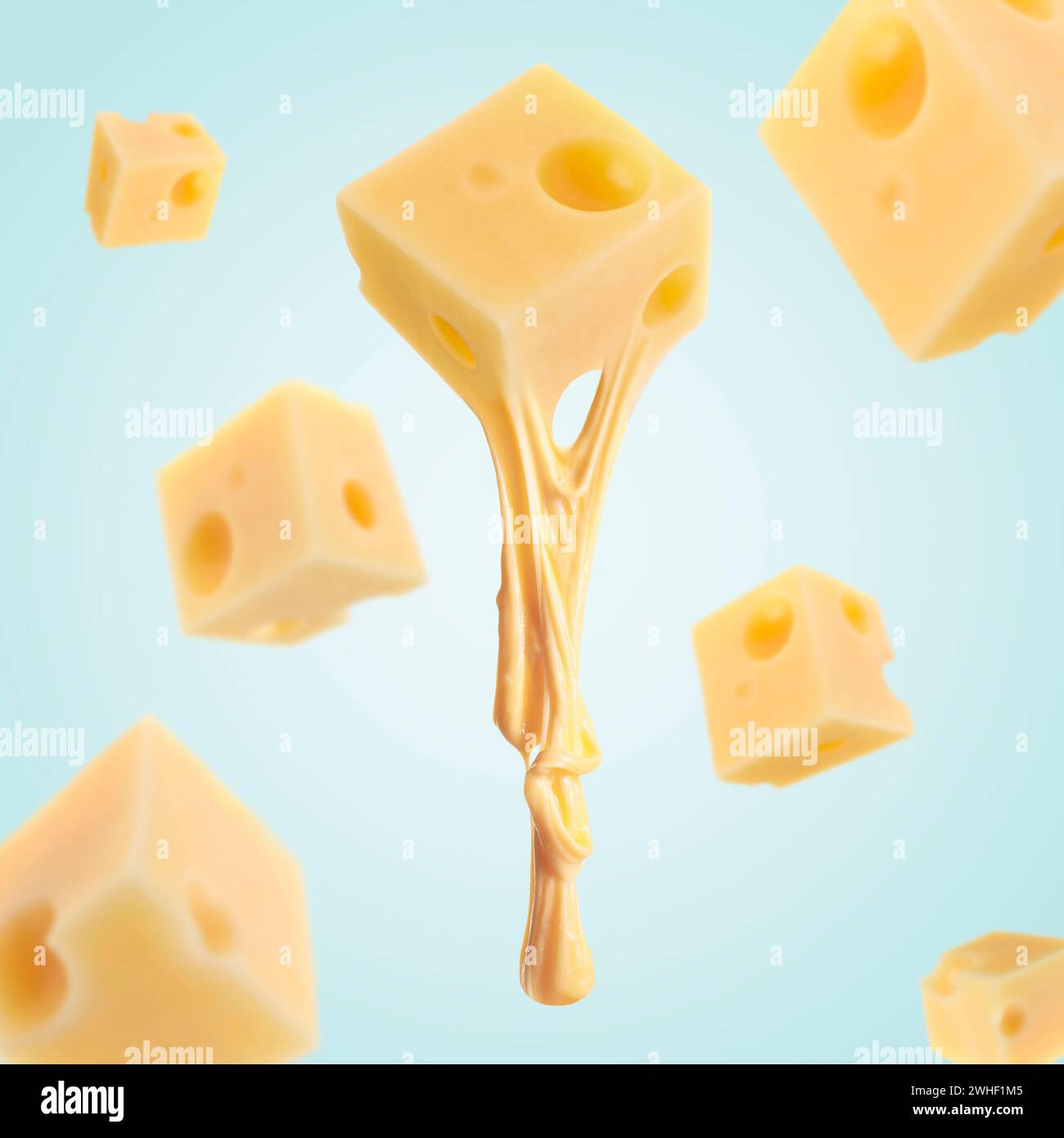 Pieces of cheese falling on light blue background Stock Photo - Alamy