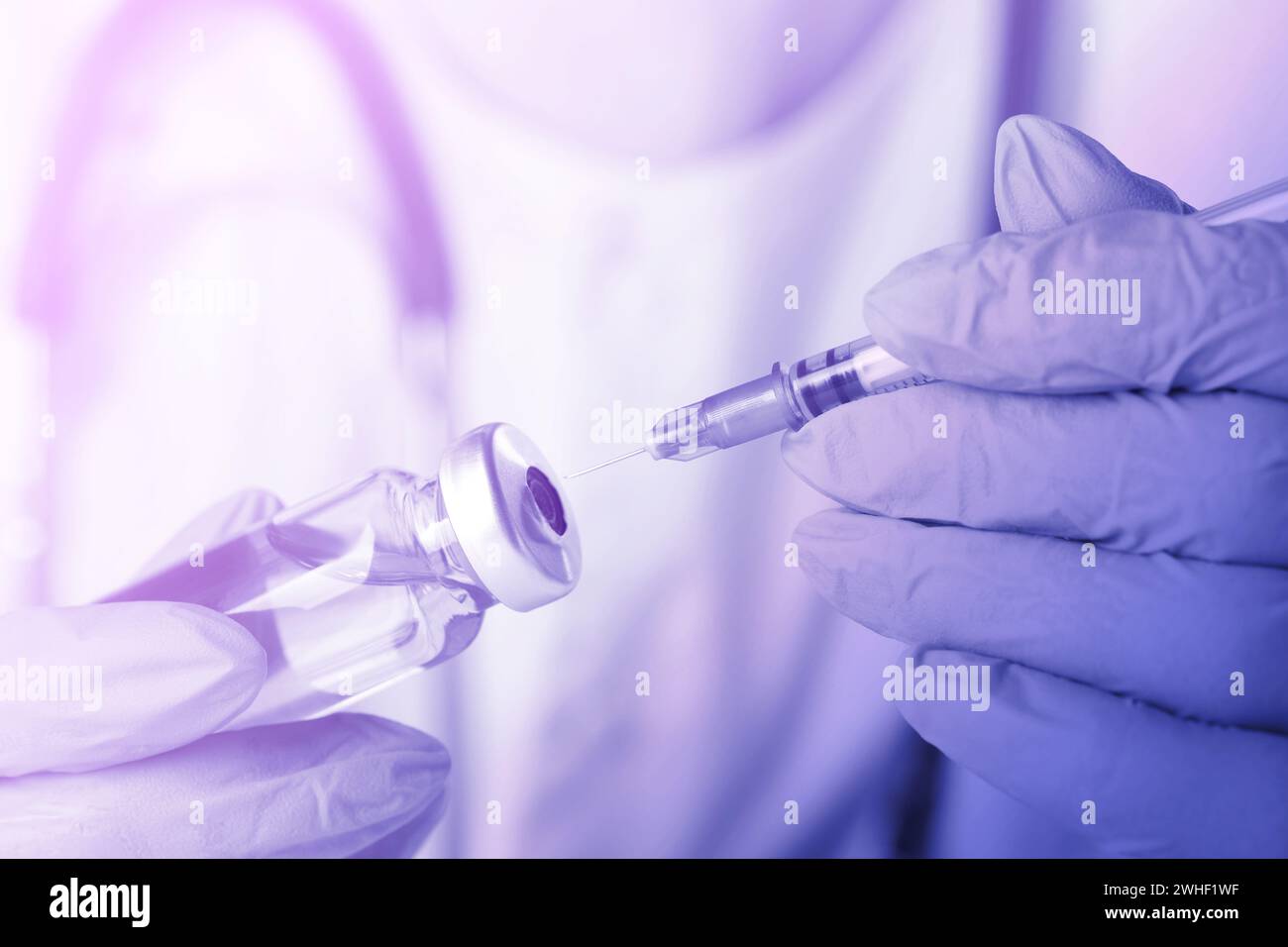 Doctor filling syringe with medication from vial, toned in purple Stock ...