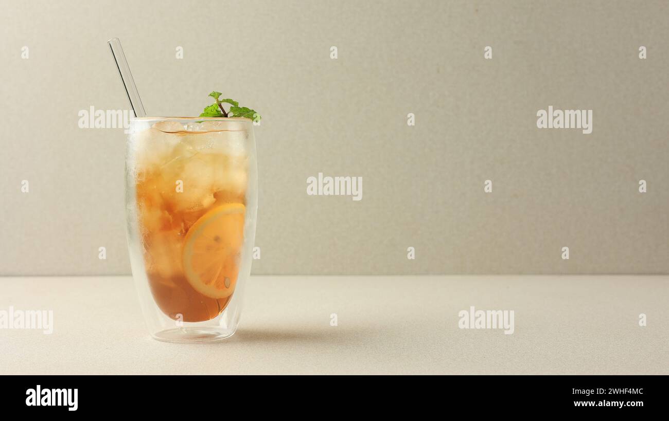 Iced Lemon Tea or Es Teh on Cream Background with Glass Straw Stock ...