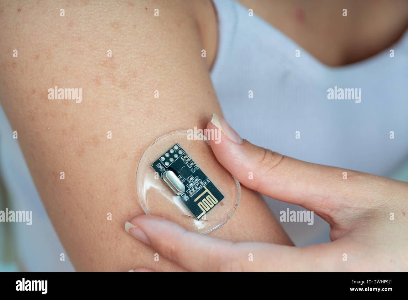 Person applying health monitoring sensor to arm Stock Photo - Alamy