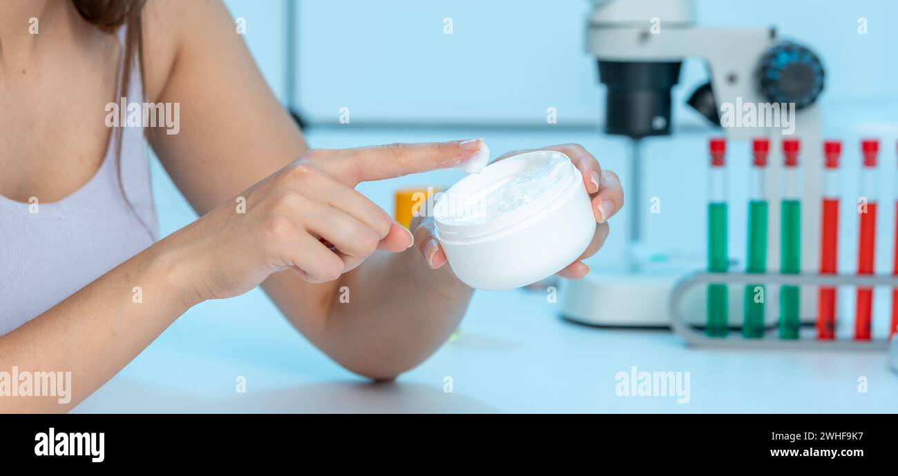 Woman using cream from jar Stock Photo - Alamy