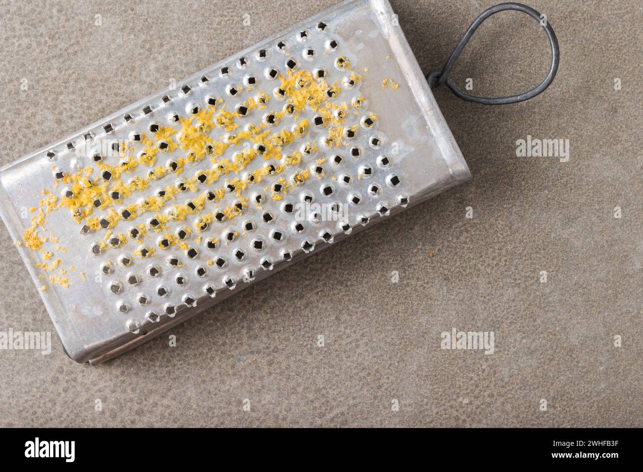 Metal scraper with lemon zest Stock Photo - Alamy