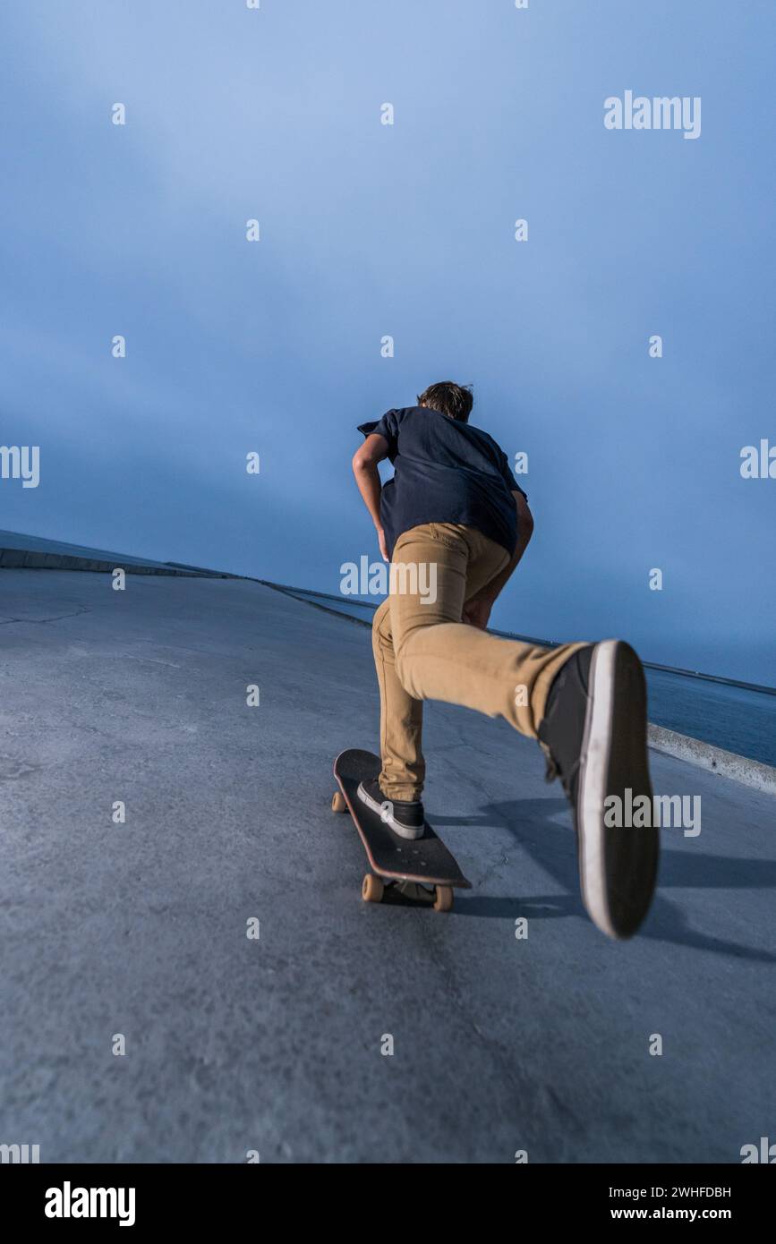 Skateboarder pushing on a concrete pavement Stock Photo - Alamy