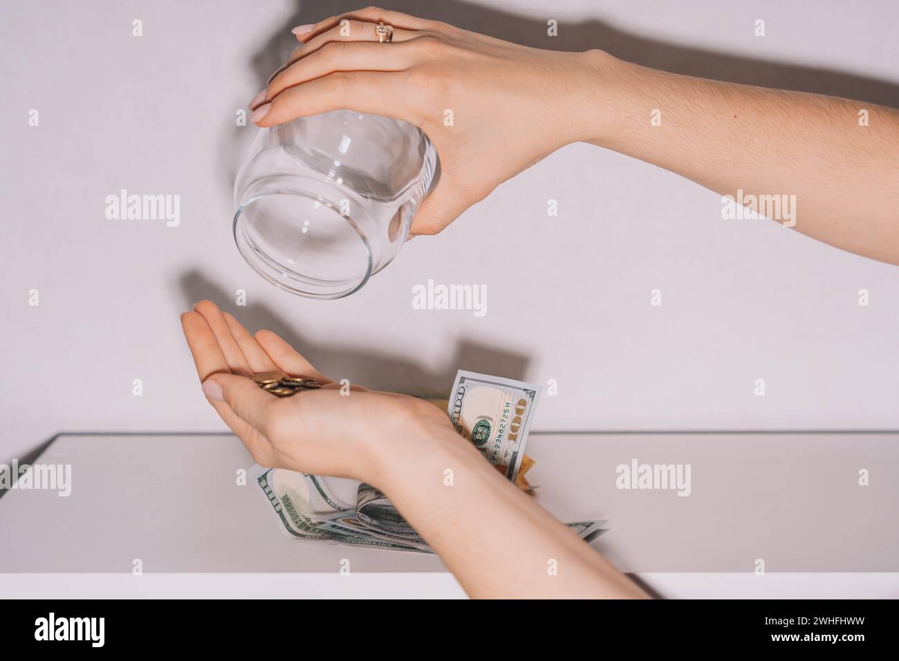Hands take out dollar bills and coins from a glass jar Stock Photo - Alamy