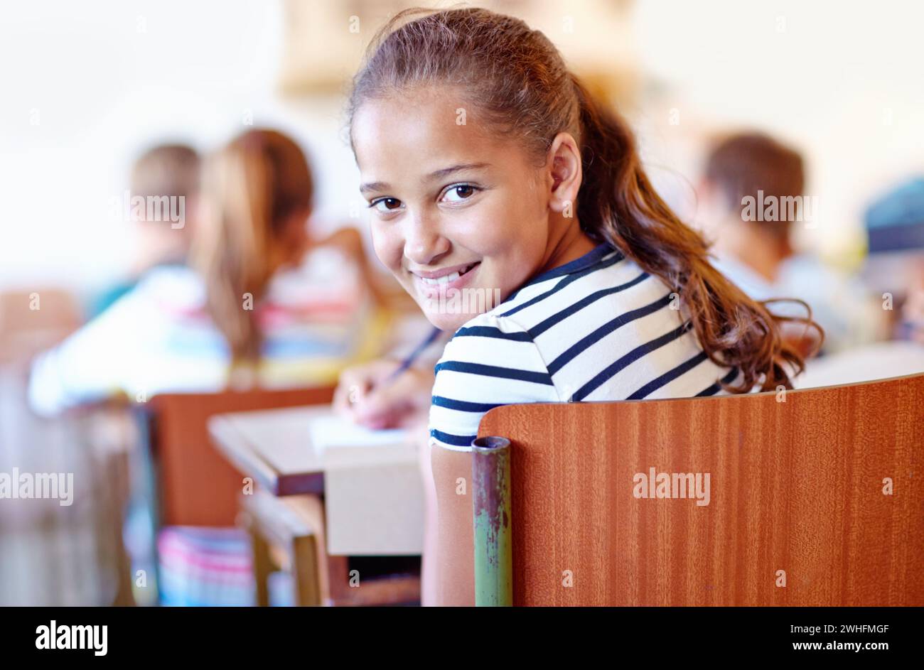 Child, portrait and school desk in classroom with notebook or lesson ...