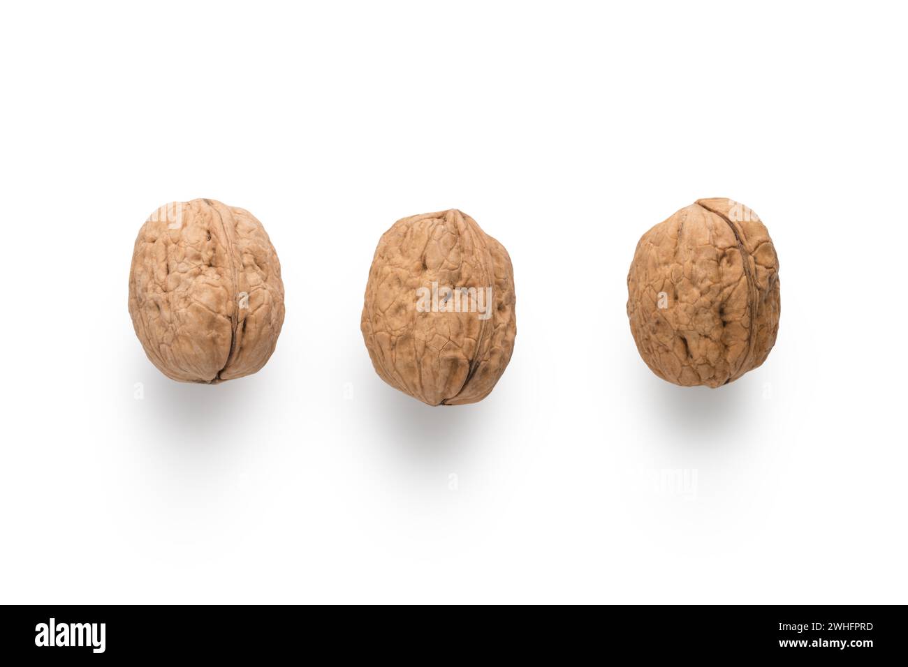 Three walnuts top view on white background, from above Stock Photo - Alamy