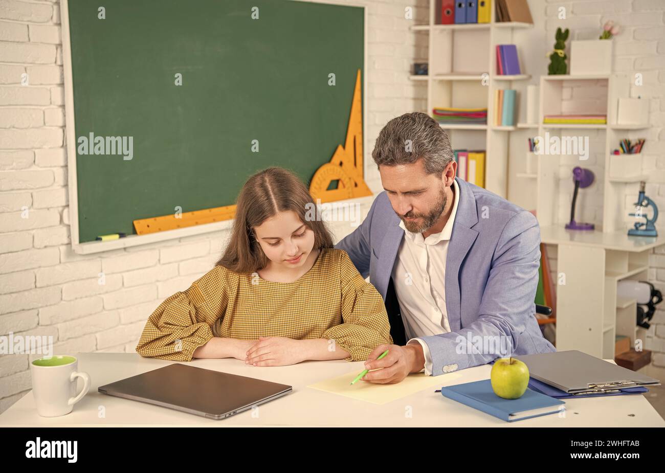 busy child study in classroom with tutor Stock Photo - Alamy