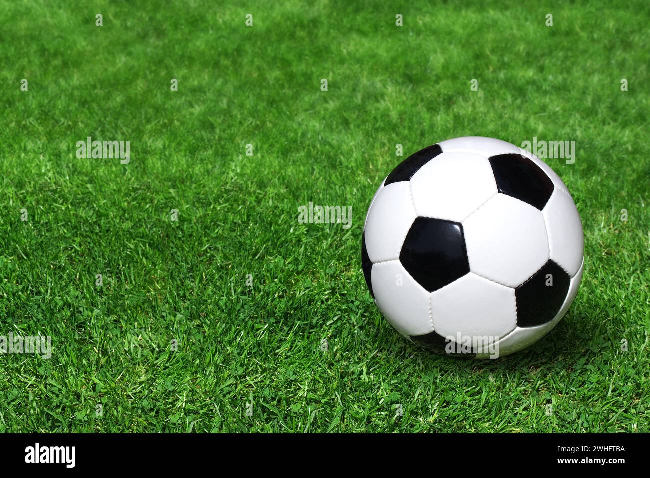 Classic football on grass field Stock Photo - Alamy