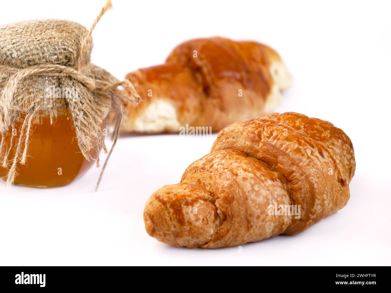 Croissant with crispy crust and honey in a jar with burlap Stock Photo ...