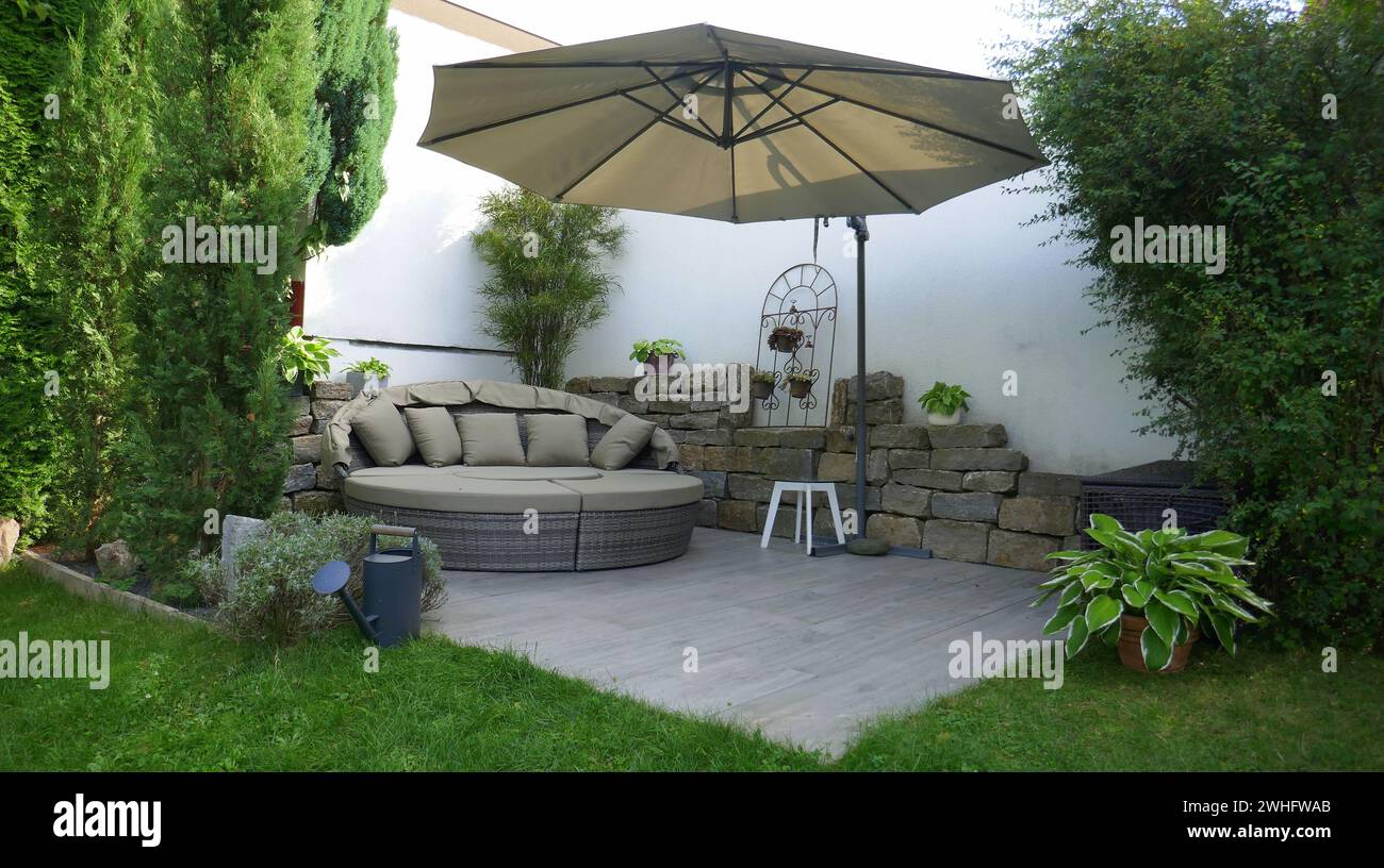 Garden terrace with lounge group and parasol in a garden corner Stock ...