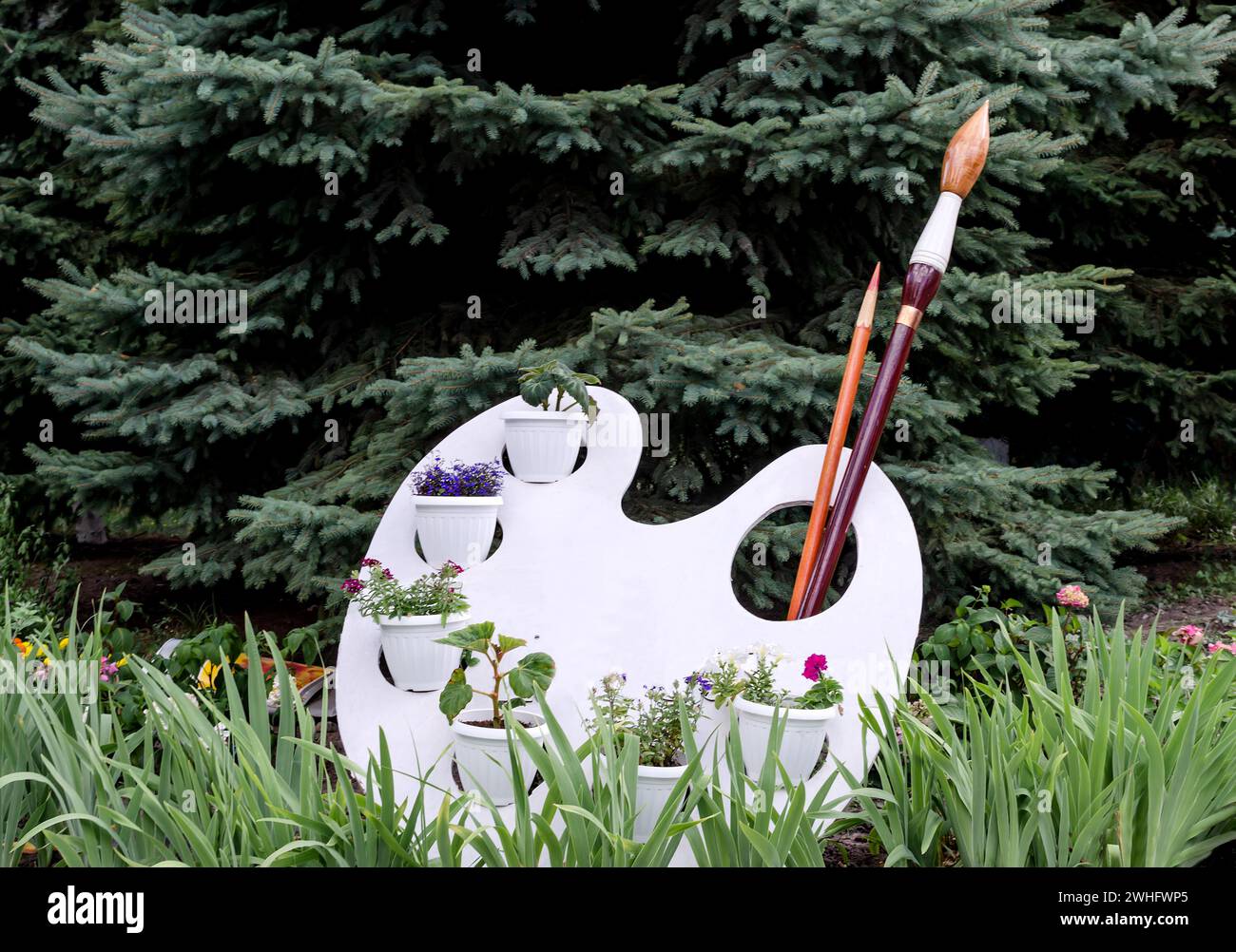 Flower bed in the form of an artist's palette with a pencil and a brush ...