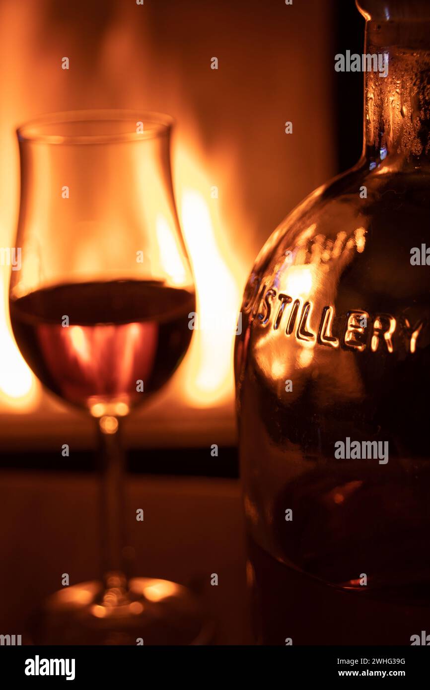 Bottle of whisky and a glass in front of fire Stock Photo - Alamy