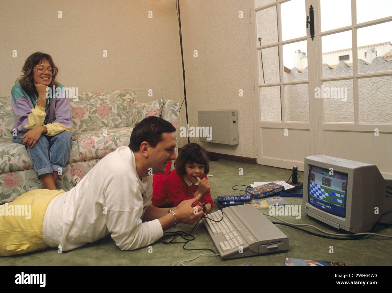 french family playing computer games in bedroom father with hi daughter ...