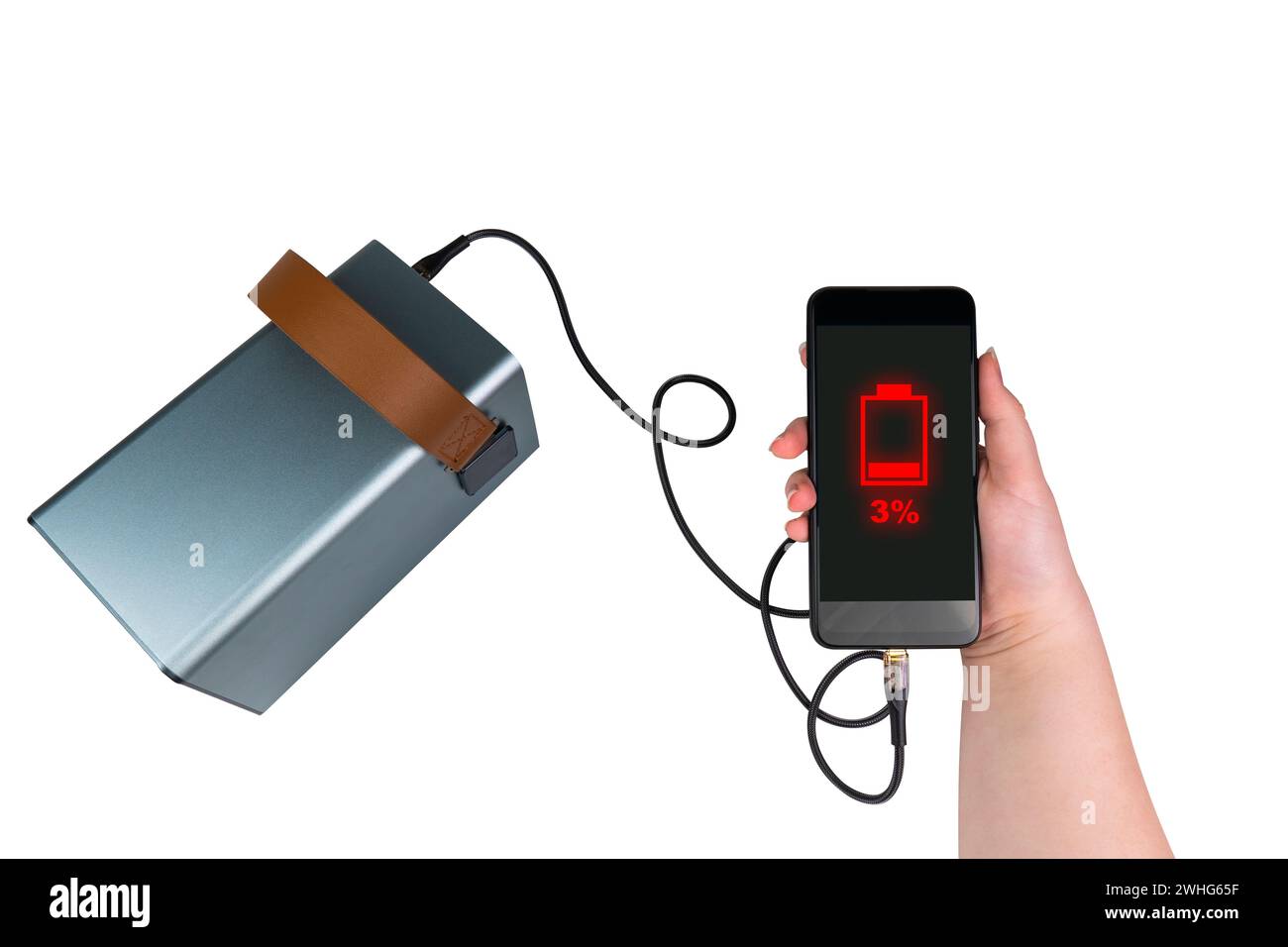 Smartphone in hand is charged from a power bank via a USB cable on a ...
