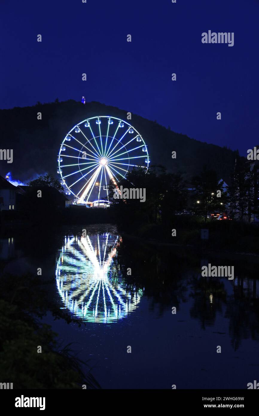 Illuminated ferris wheel and reflection on the river Werra in Eschwege ...