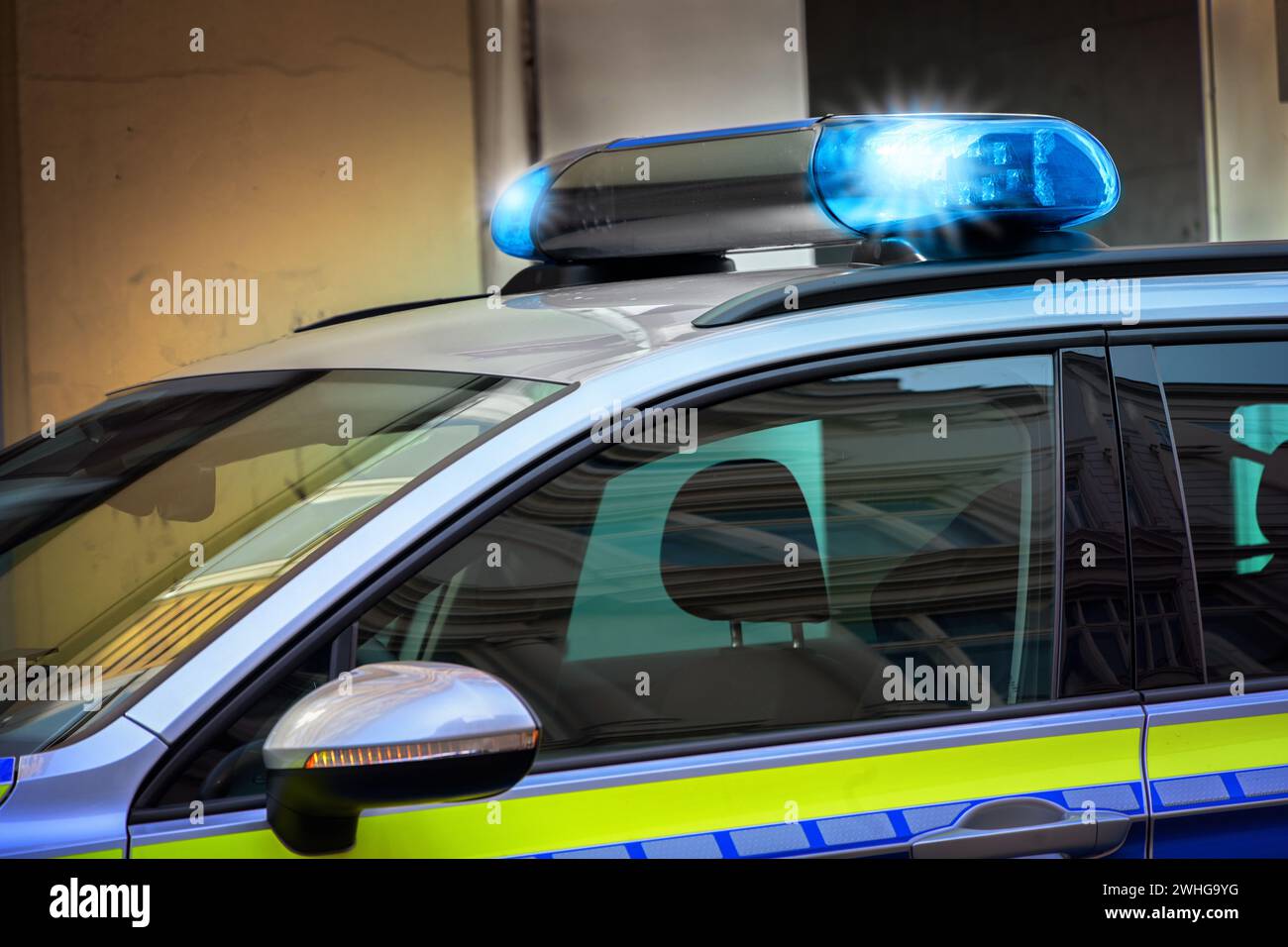 German police car with blue light on standing in the city, copy space ...