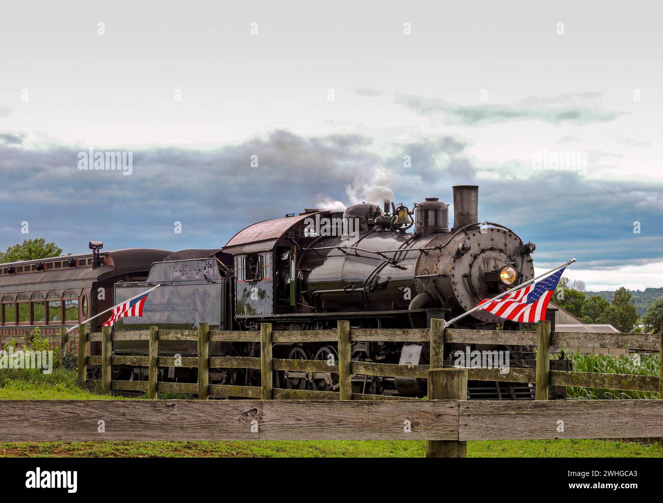 American Flags are Waving in the Wind, on a Fence, While a Steam ...