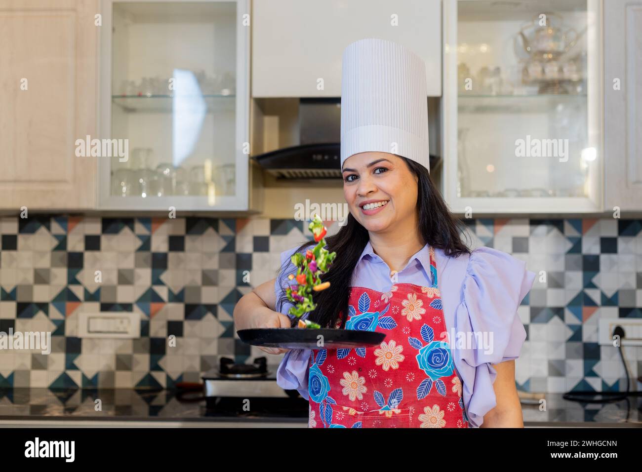 Beautiful indian woman dressed in cook uniform wearing a apron, chef ...