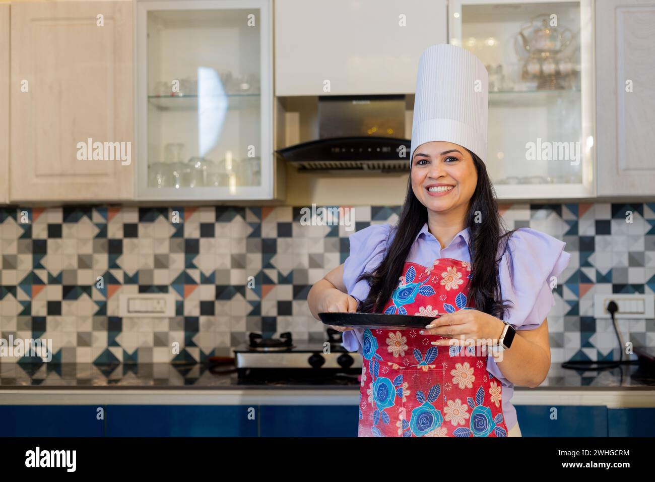 Beautiful indian woman dressed in cook uniform wearing a apron, chef ...