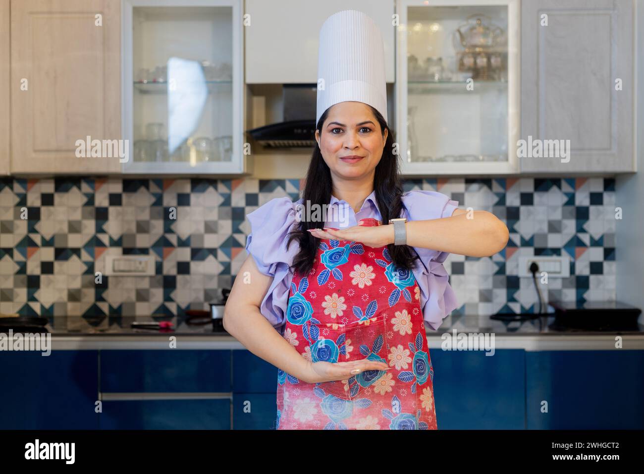 Beautiful indian woman dressed in cook uniform wearing a apron, chef ...