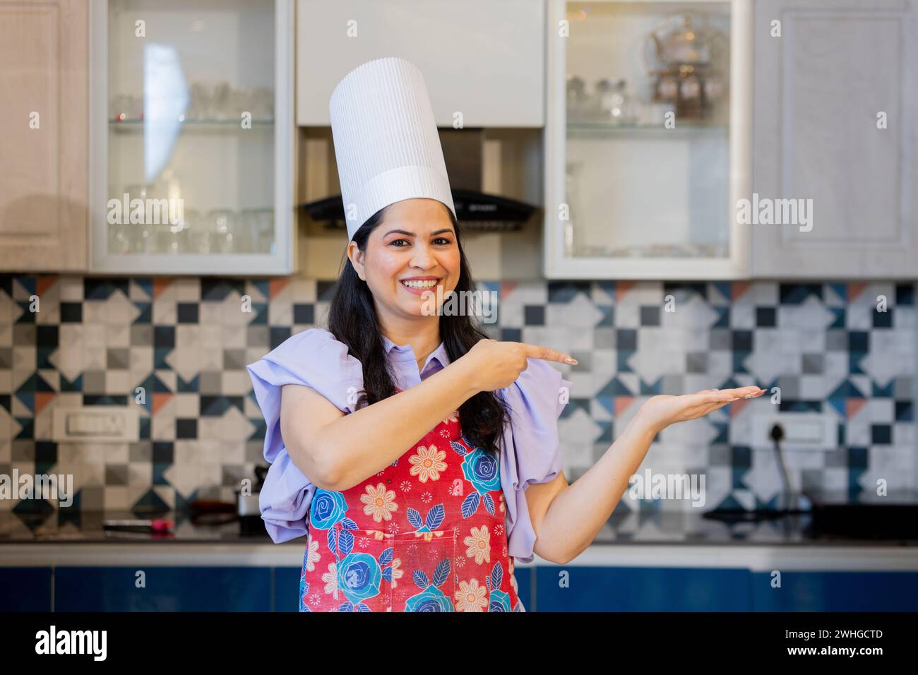 Beautiful indian woman dressed in cook uniform wearing a apron, chef ...