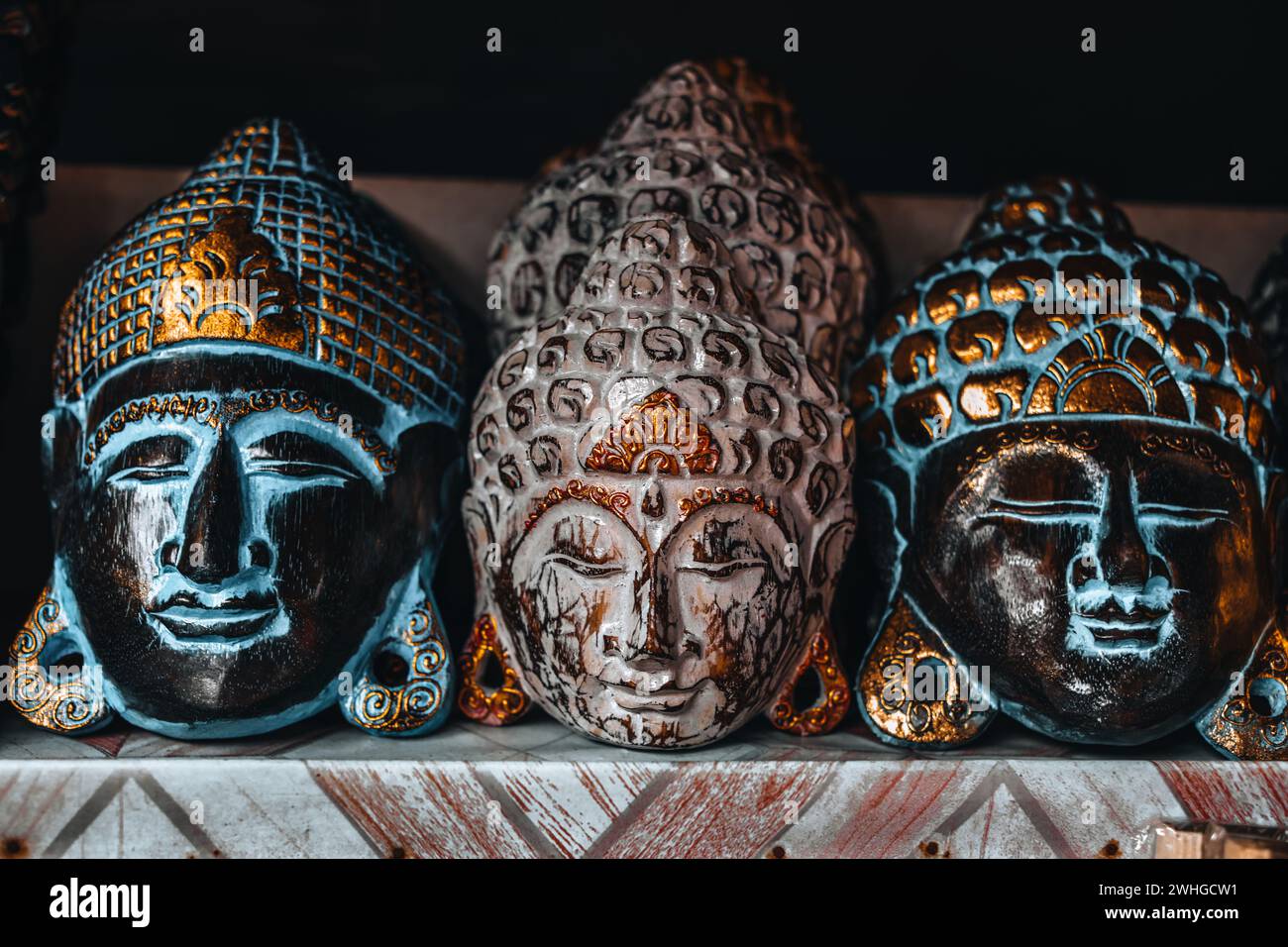 Handmade gold plated Buddha face masks on a counter in a street shop on ...