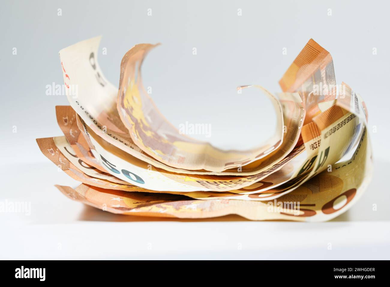 Stack of half-rolled 50 euro bills on a light gray background, money ...